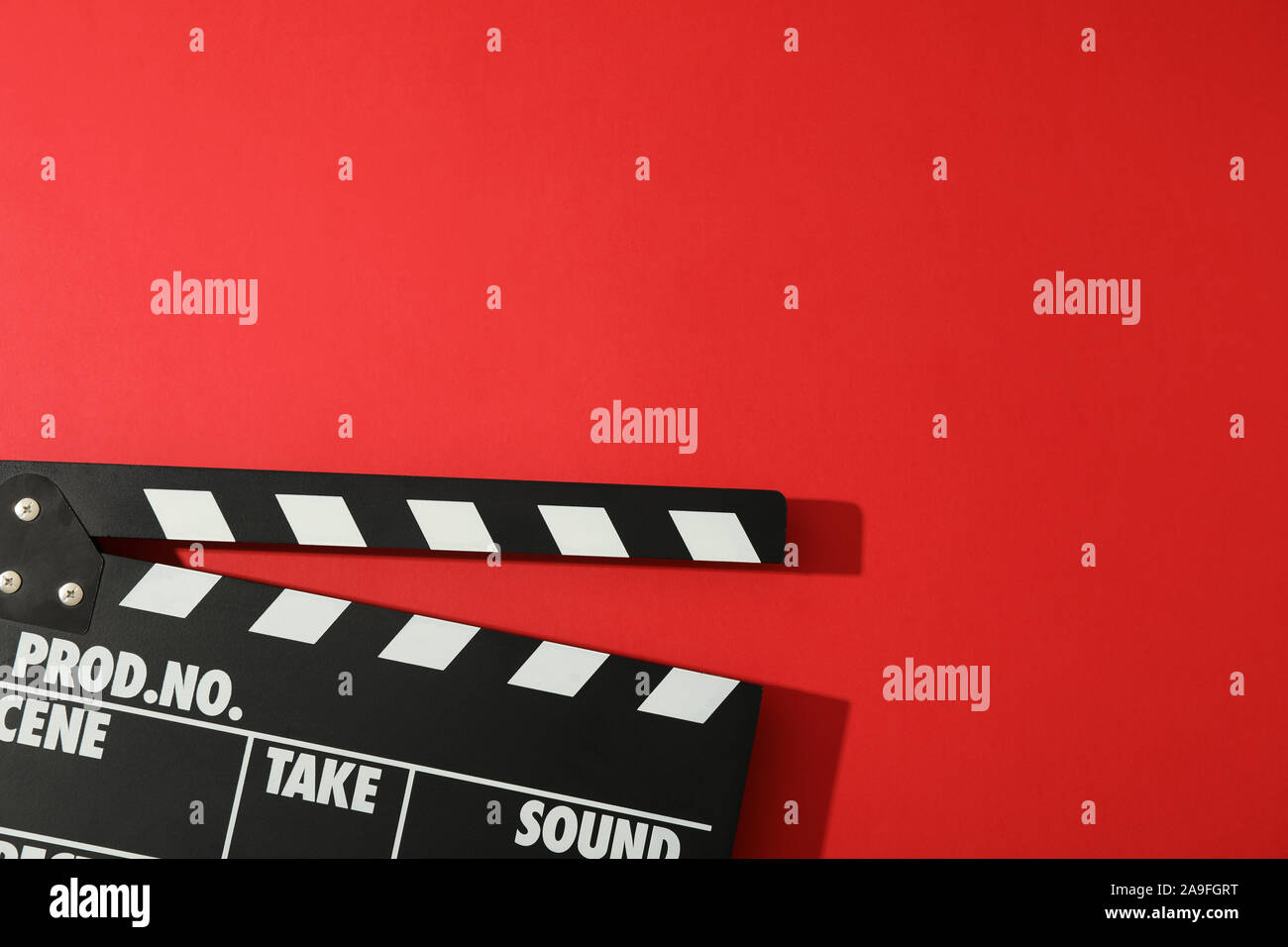 Black clapperboard on red background, space for text Stock Photo - Alamy