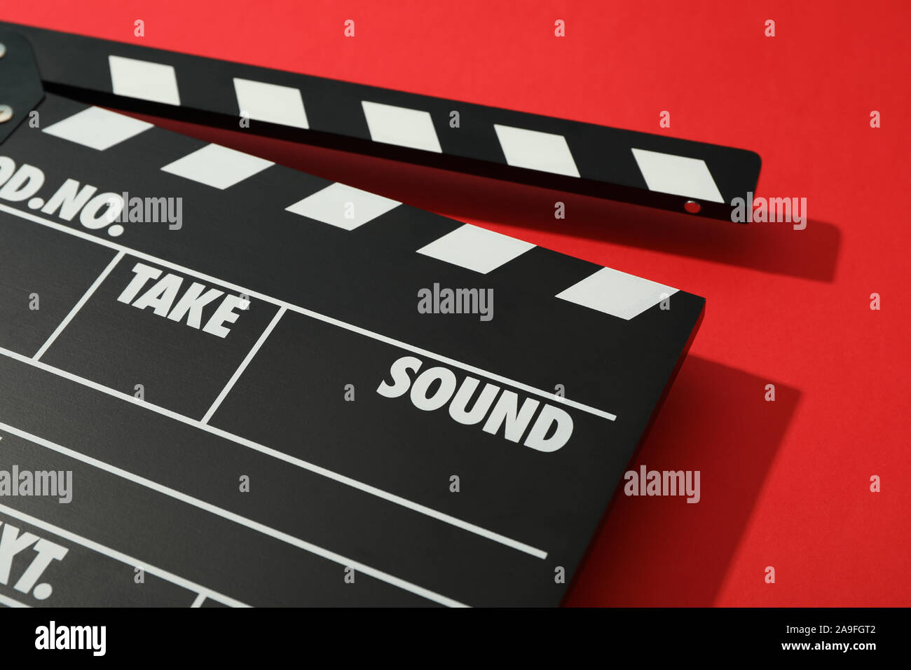 Black clapperboard on red background, space for text Stock Photo - Alamy
