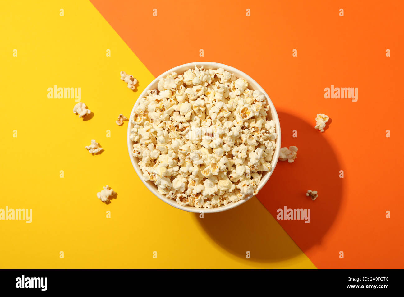 Flat lay composition. Bucket with popcorn on two tone background Stock ...