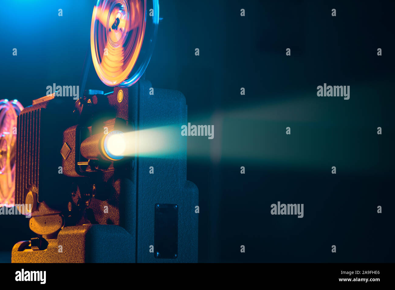 Vintage old fashioned projector in a dark room projecting a film ...