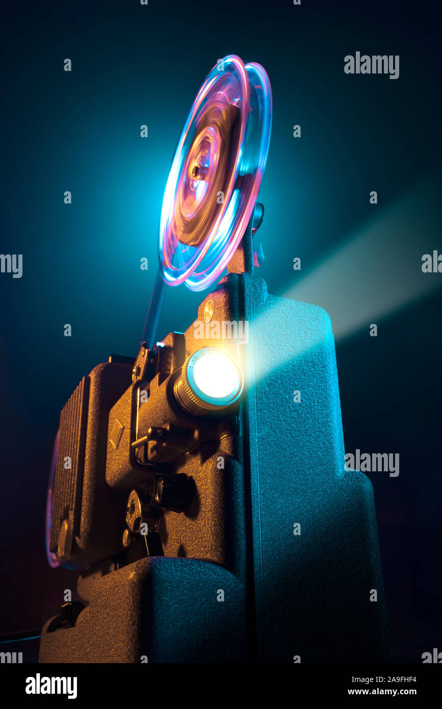 Vintage old fashioned projector in a dark room projecting a film ...