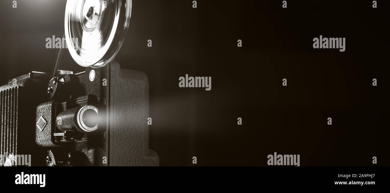 Vintage old fashioned projector in a dark room projecting a film ...