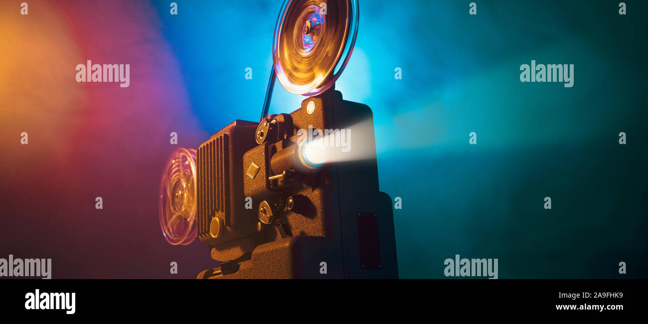 Vintage old fashioned projector in a dark room projecting a film ...