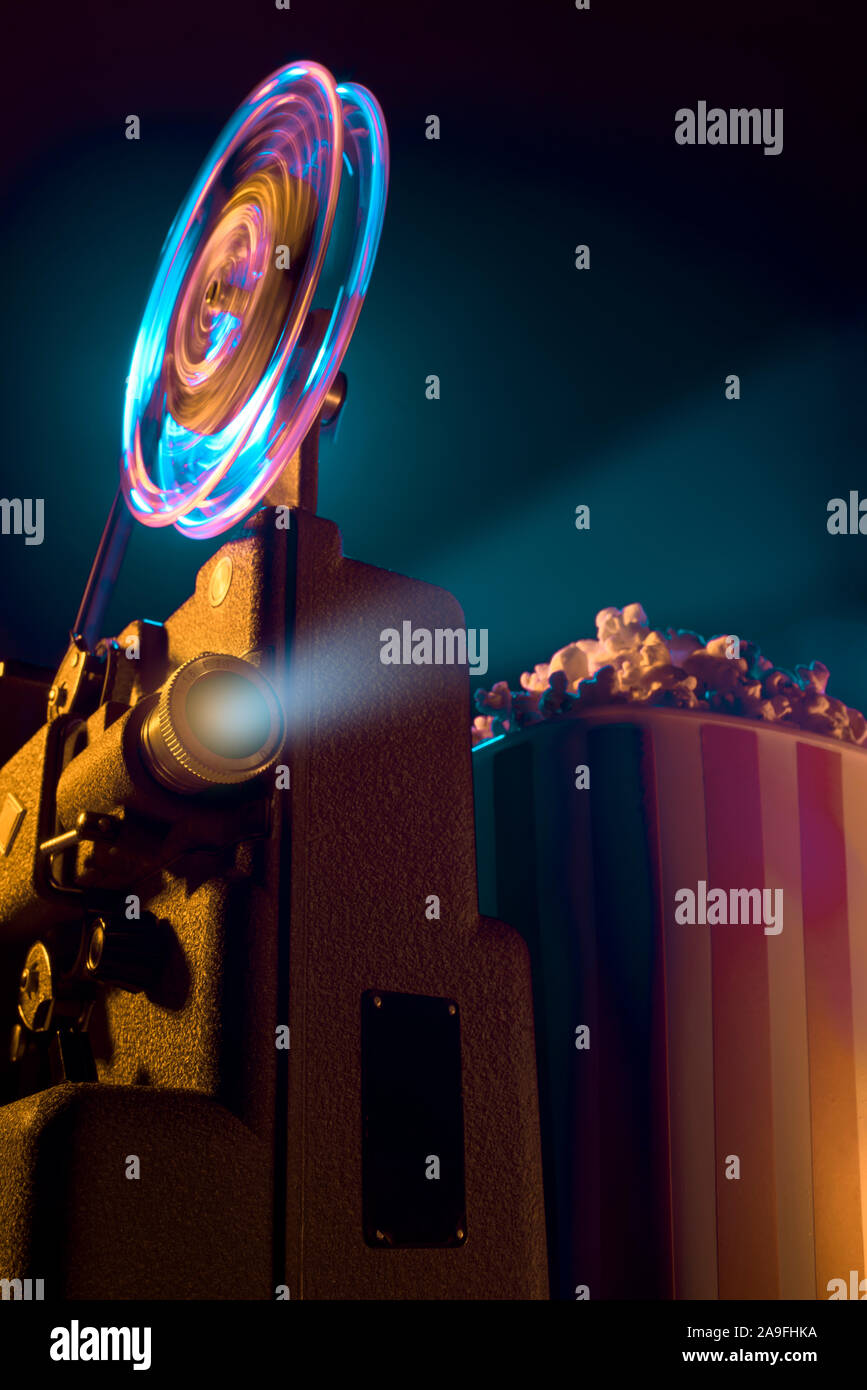 Vintage old fashioned projector in a dark room projecting a film ...