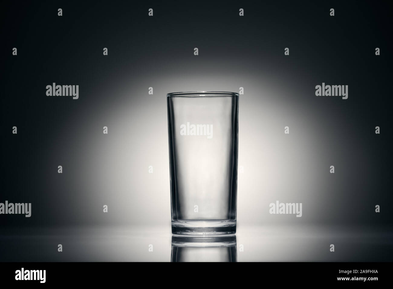 one empty glass for water on a dark background Stock Photo - Alamy