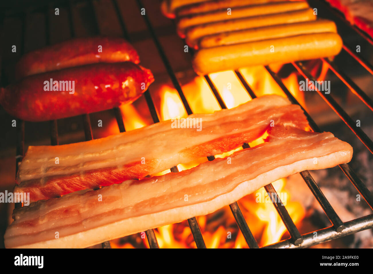 Chorizo, bacon and sausages prepared on the grill during a barbecue ...