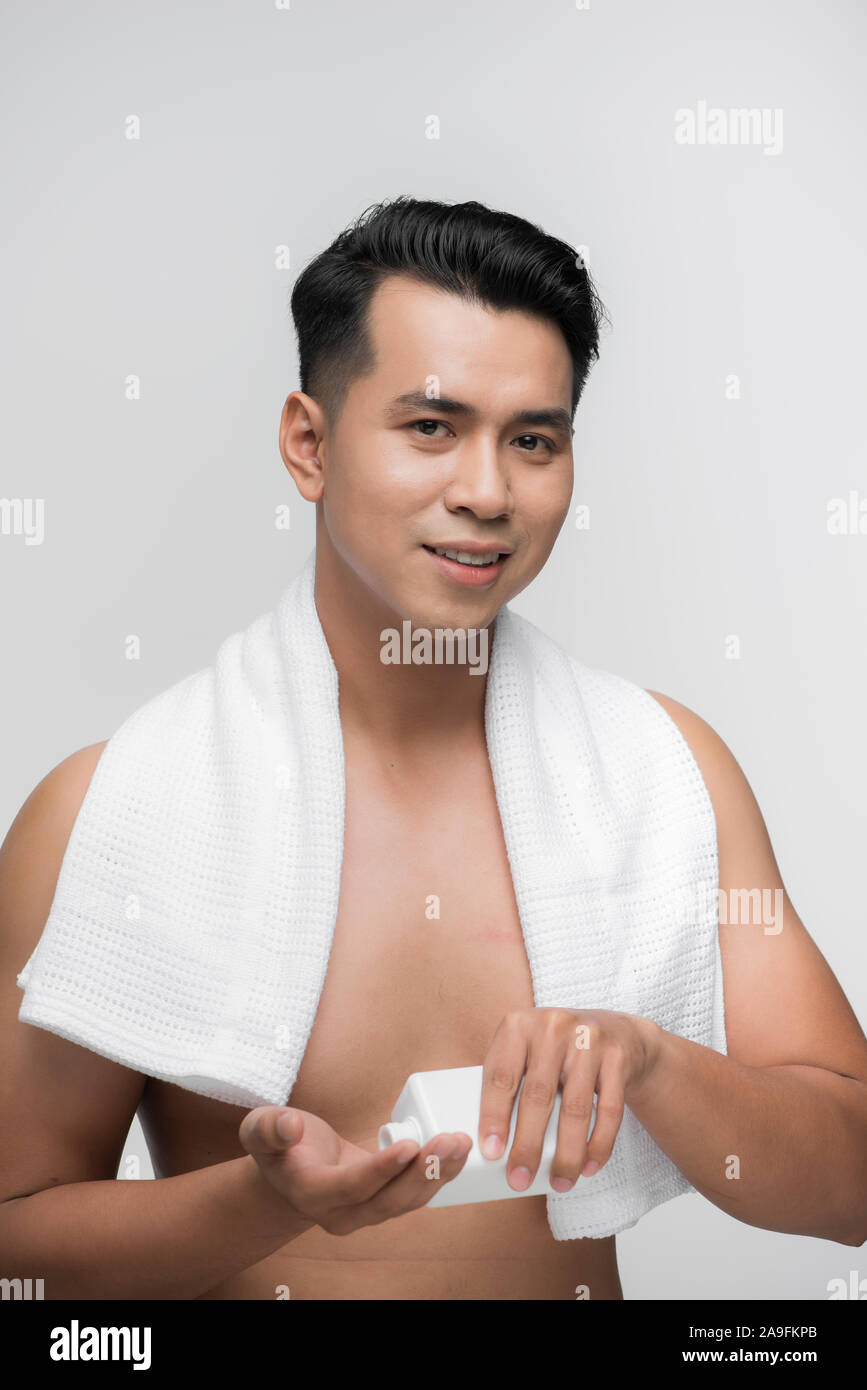 Asian man in bathroom applying facial lotion Stock Photo - Alamy