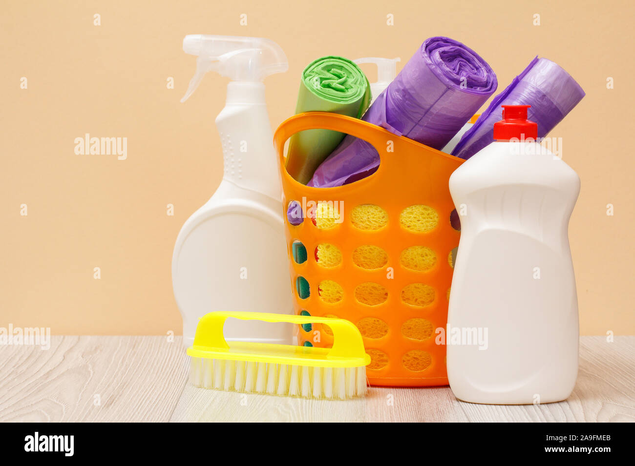 Plastic bottles of glass and tile cleaner, basket with garbage bags ...