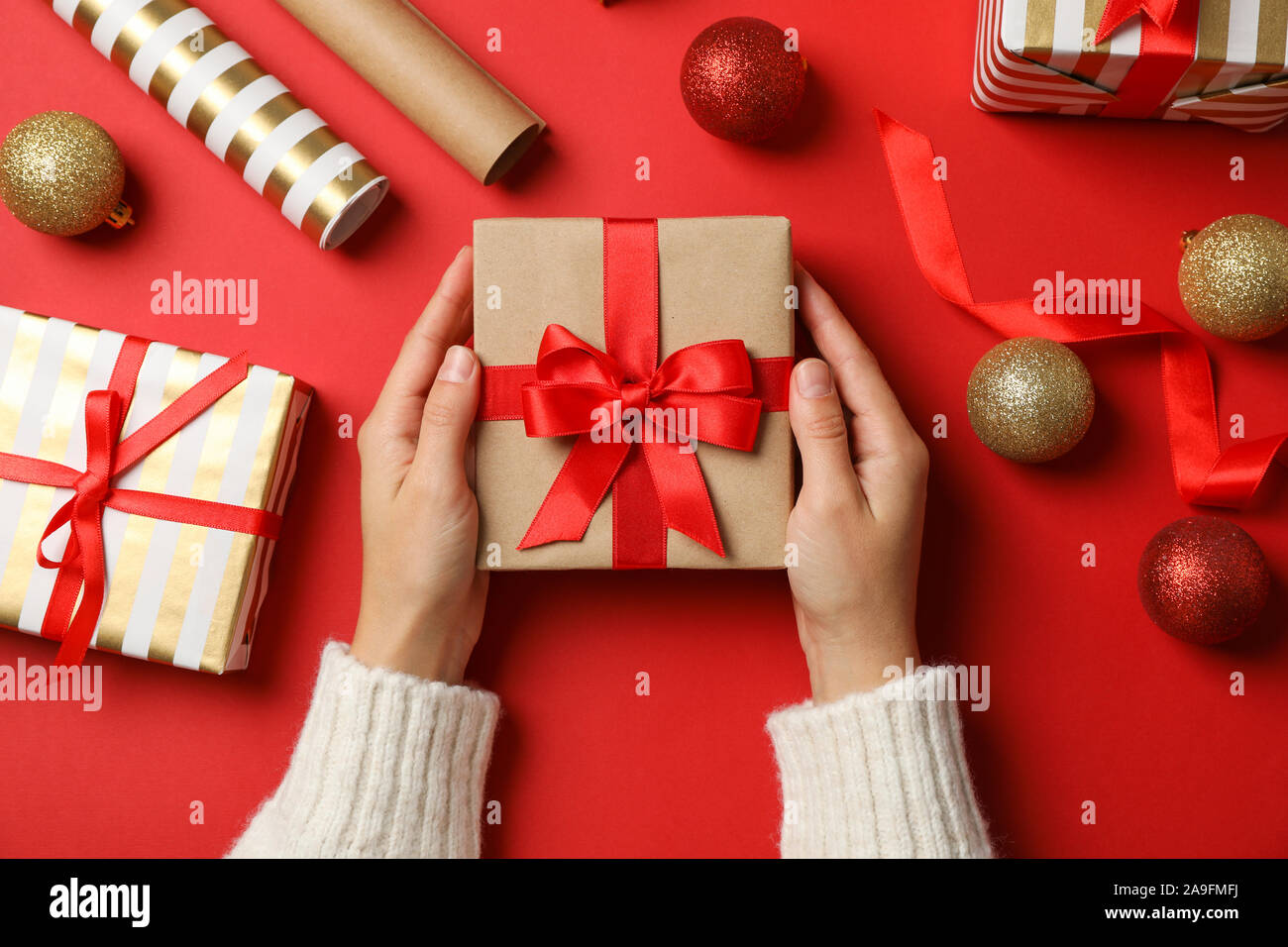 Female hands holding present on decorated background, top view Stock ...