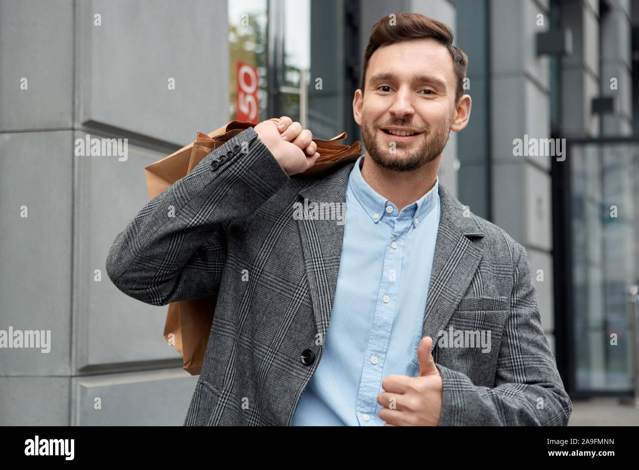 Happy man showing shopping bags hi-res stock photography and images - Alamy