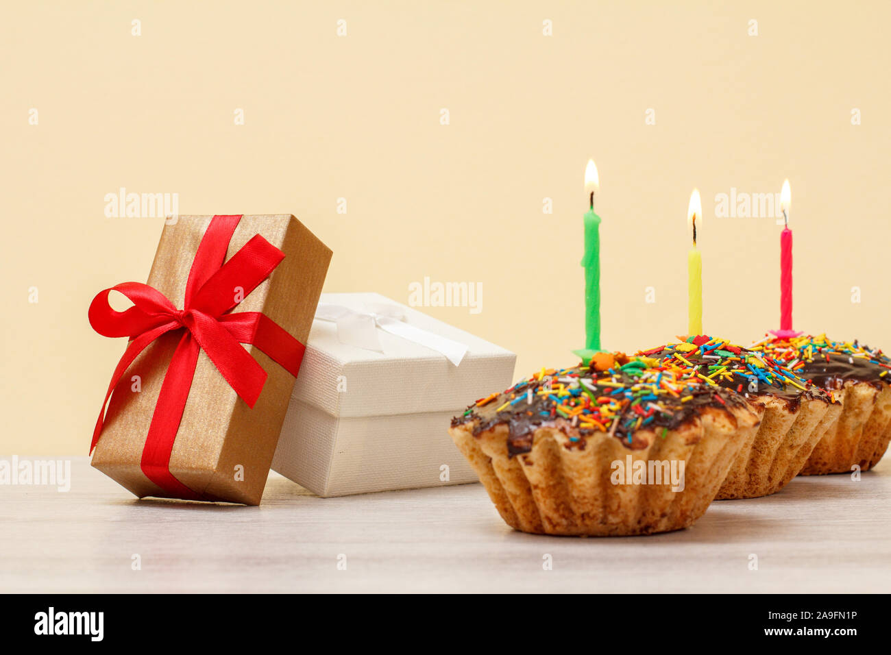 Gift boxes and tasty birthday muffins with chocolate glaze and caramel ...