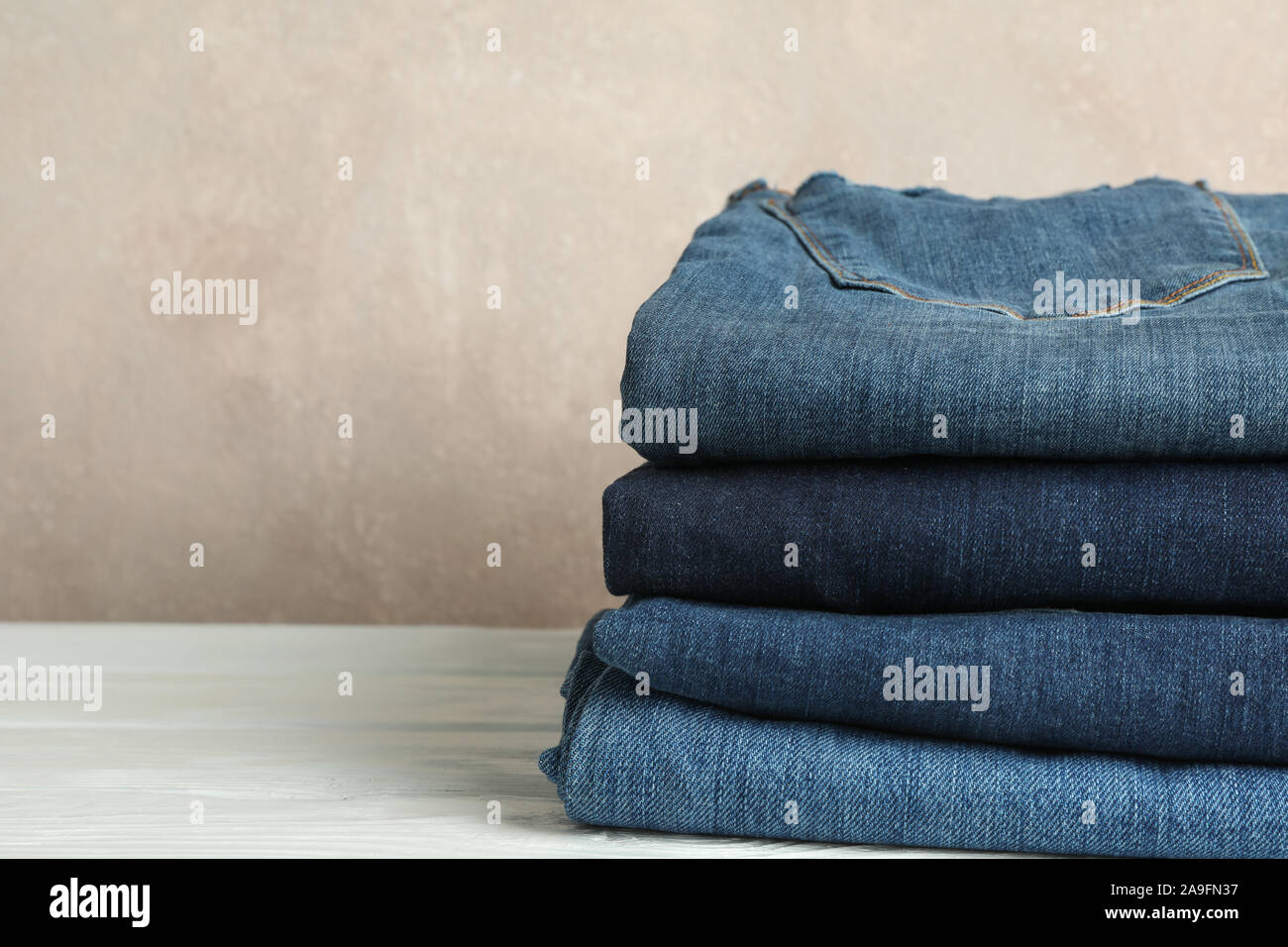 Stack of jeans pants on white background, space for text Stock Photo ...