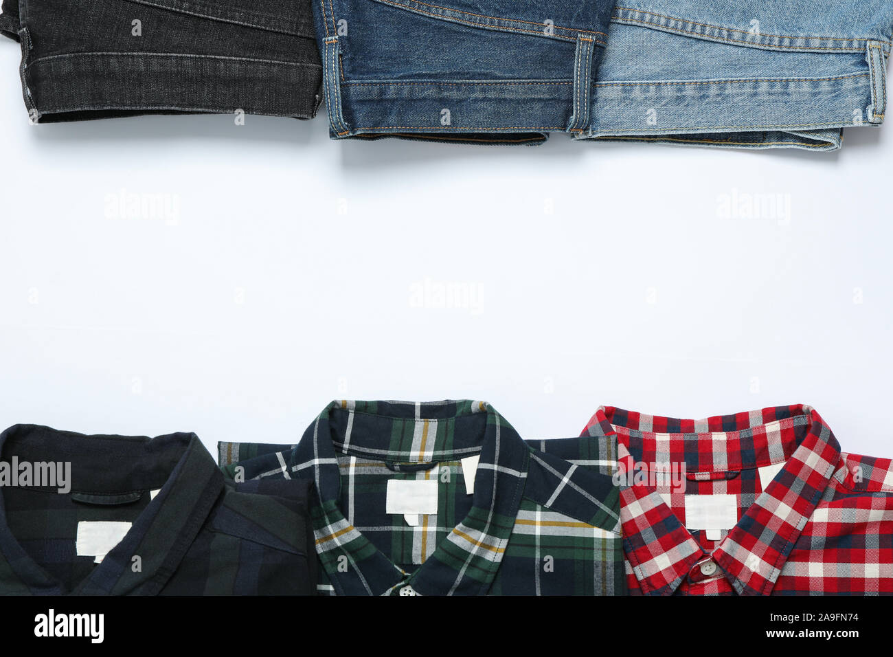 Flat lay with shirts and jeans on white background Stock Photo - Alamy