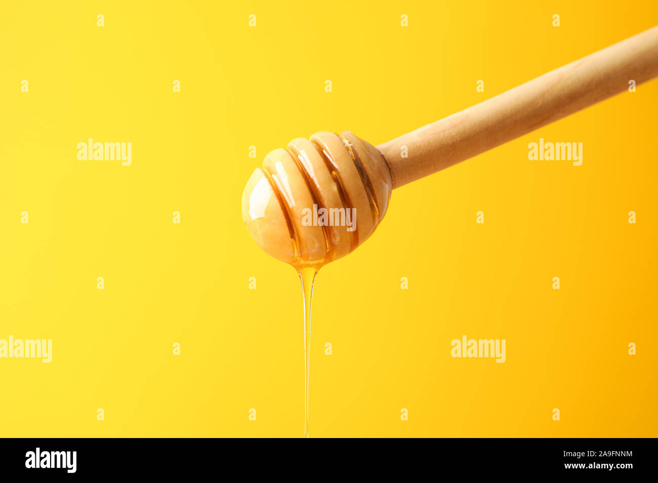 Dipper with honey on yellow background, space for text Stock Photo - Alamy