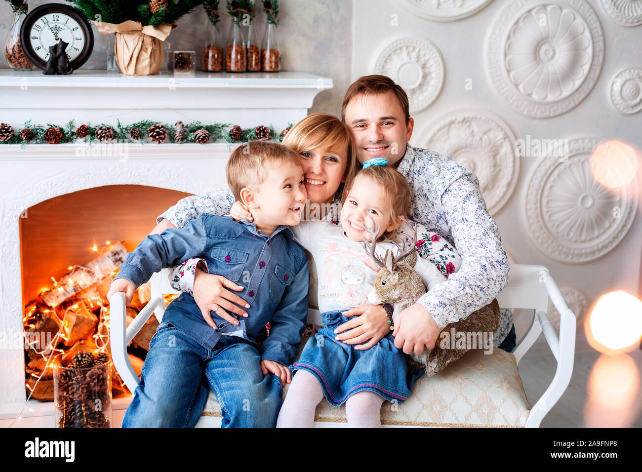 Happy family having fun together at Christmas eve near fireplace Stock ...