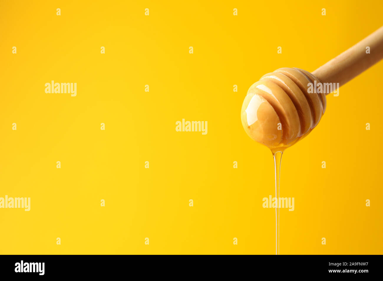Dipper with honey on yellow background, space for text Stock Photo - Alamy
