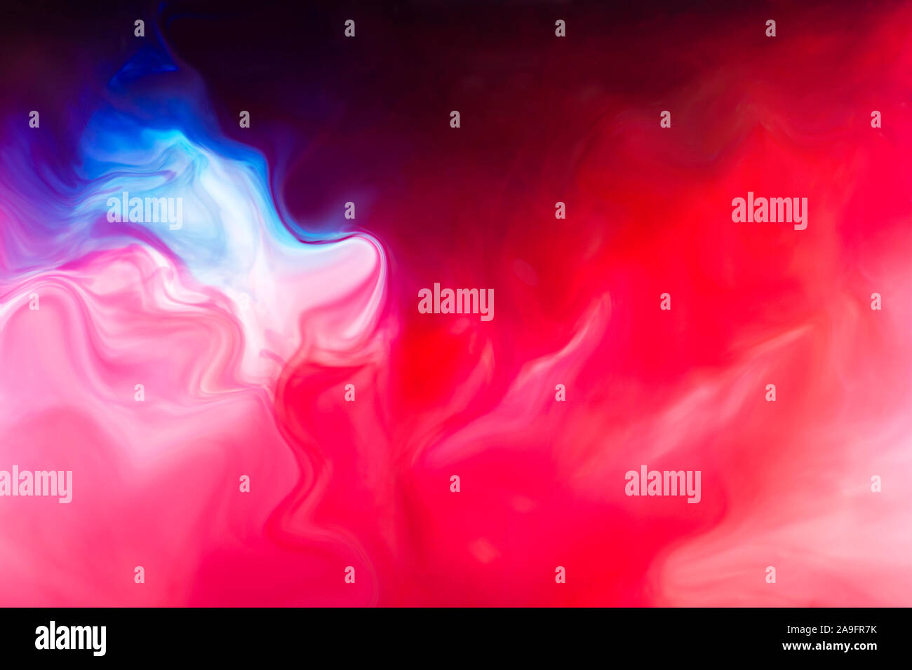 Illuminated background with red and blue fluid that diffuses into the ...
