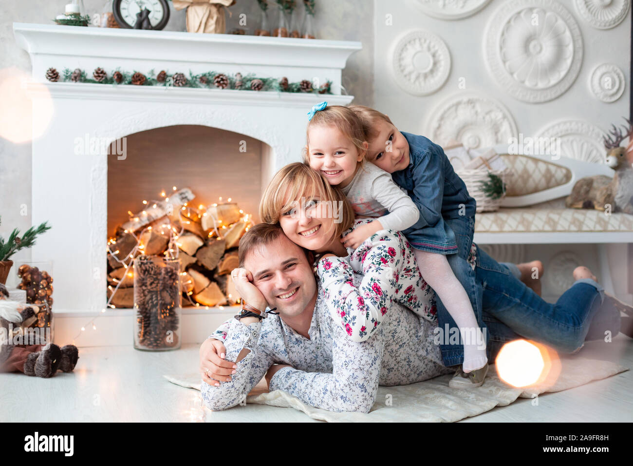 Happy family having fun together at Christmas eve near fireplace Stock ...