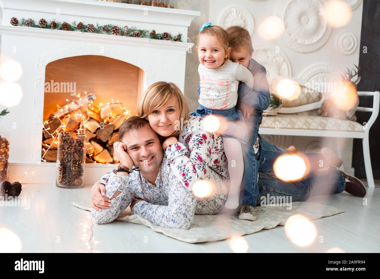 Happy family having fun together at Christmas eve near fireplace Stock ...