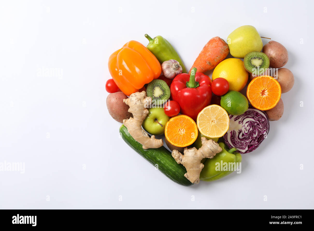 Heart laid out of vegetables and fruits on white background, copy space ...