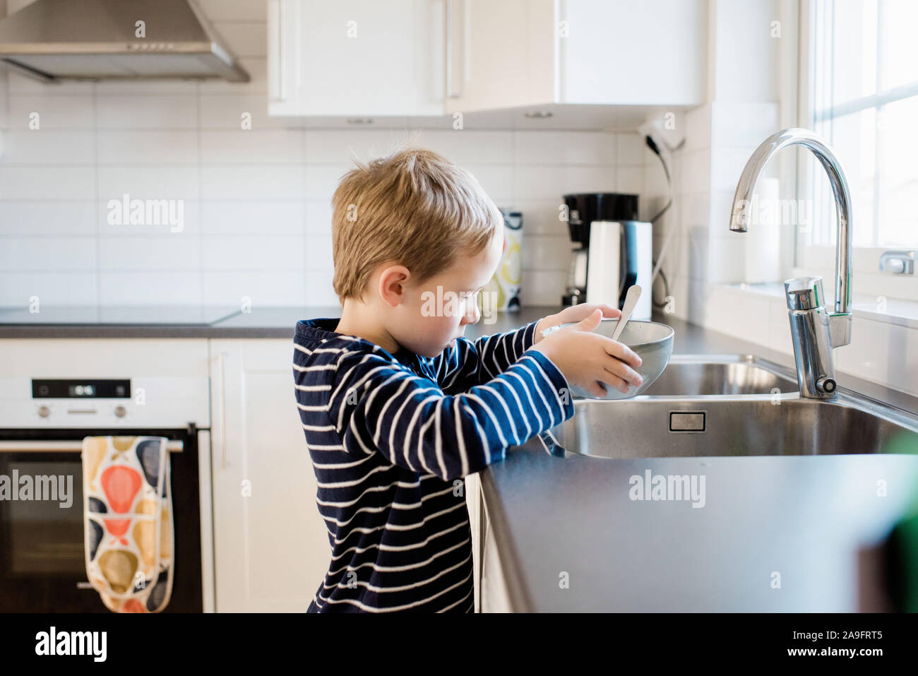 Boy helping with household chores hi-res stock photography and images ...