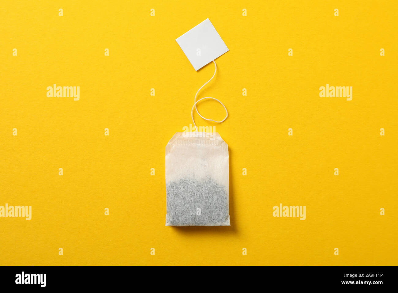 Tea bag with label on yellow background, space for text Stock Photo - Alamy