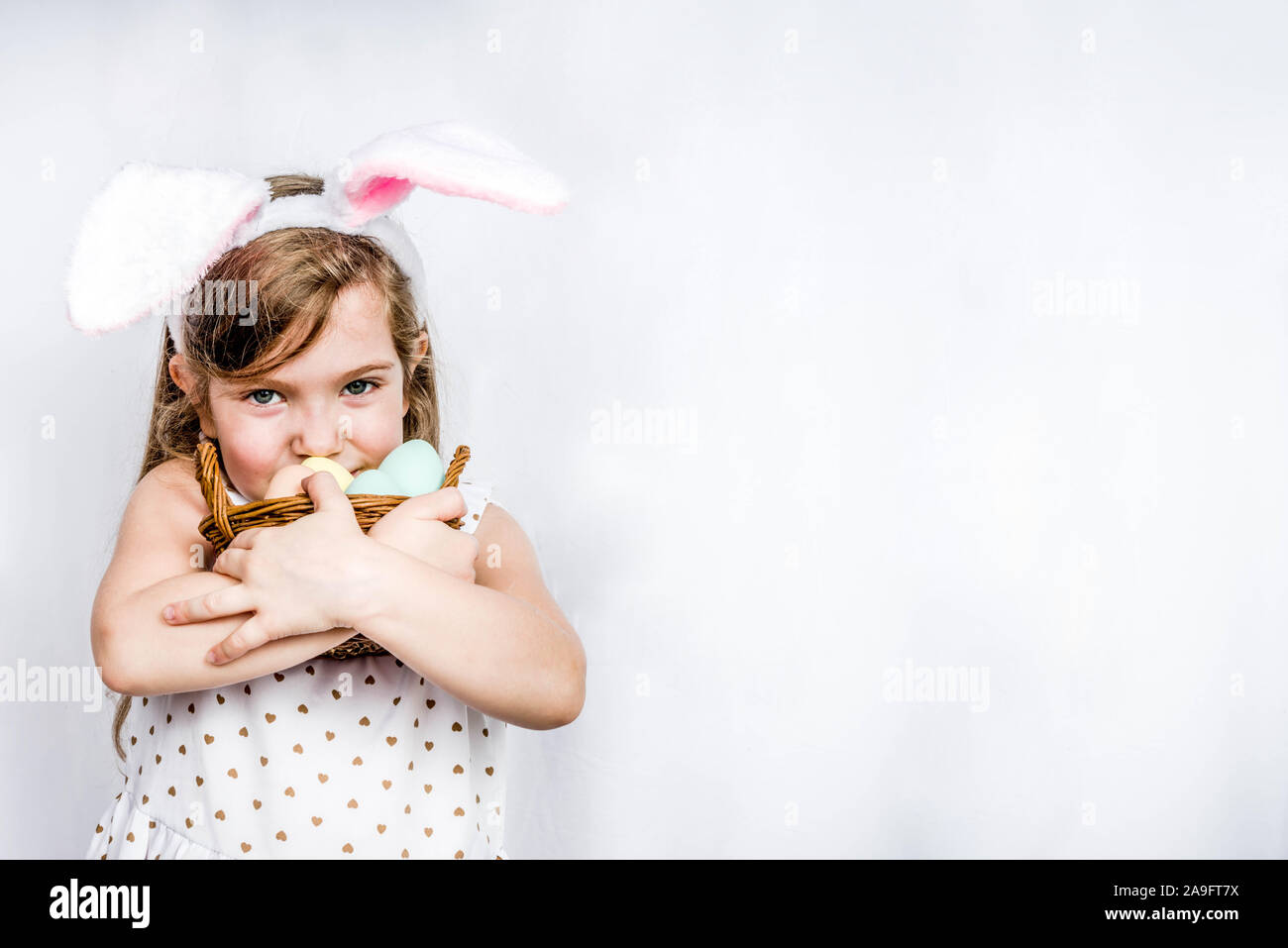 Happy cute child girl in rabbit costume with bunny ears holds basket ...