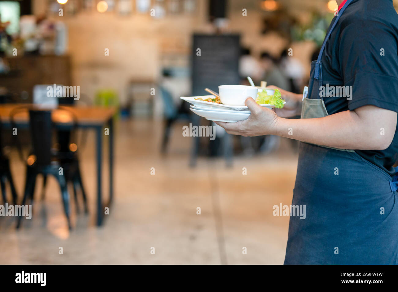 Waiter hand holding dirty dishes in the restaurant Stock Photo - Alamy