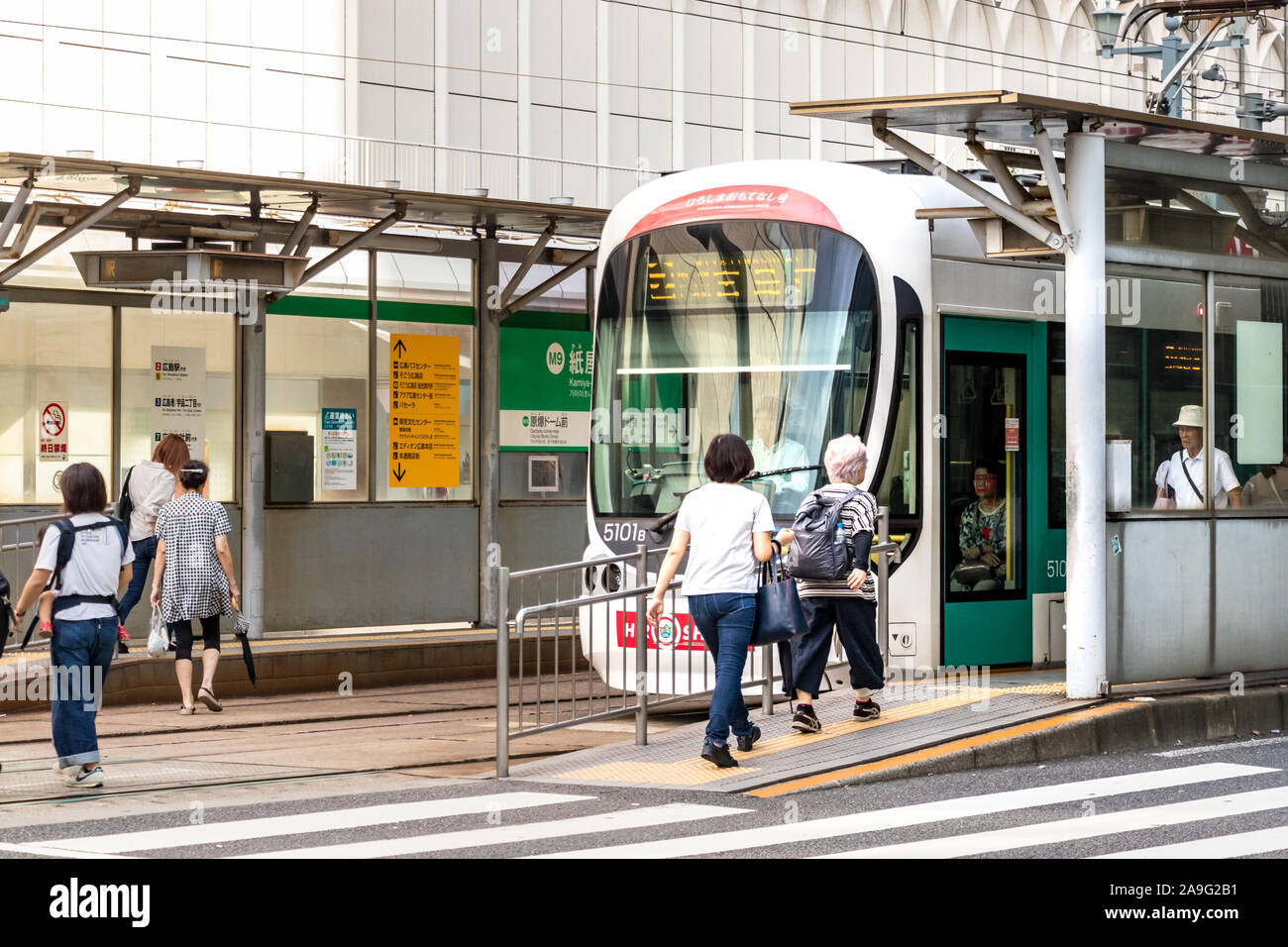 Japanese passengers boarding the tram at the Kamiyacho-nishi tram ...