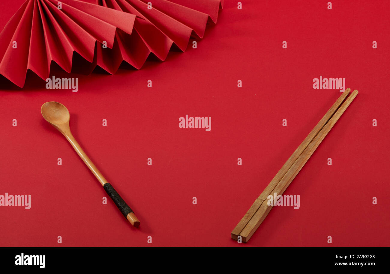 Chinese style red background and red folding fan and wooden spoon and ...