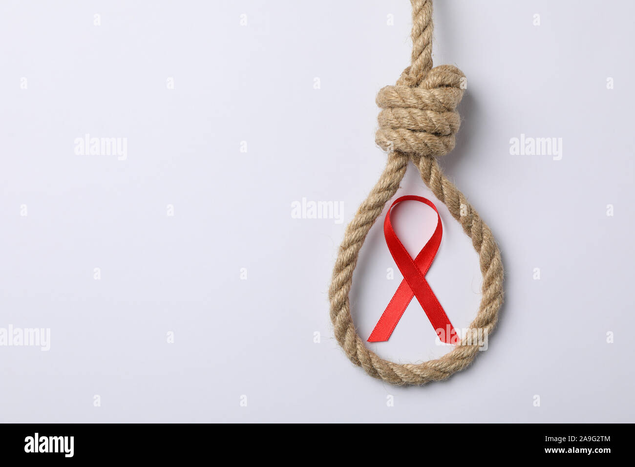 Awareness red ribbon and suicide rope on white background, copy space ...