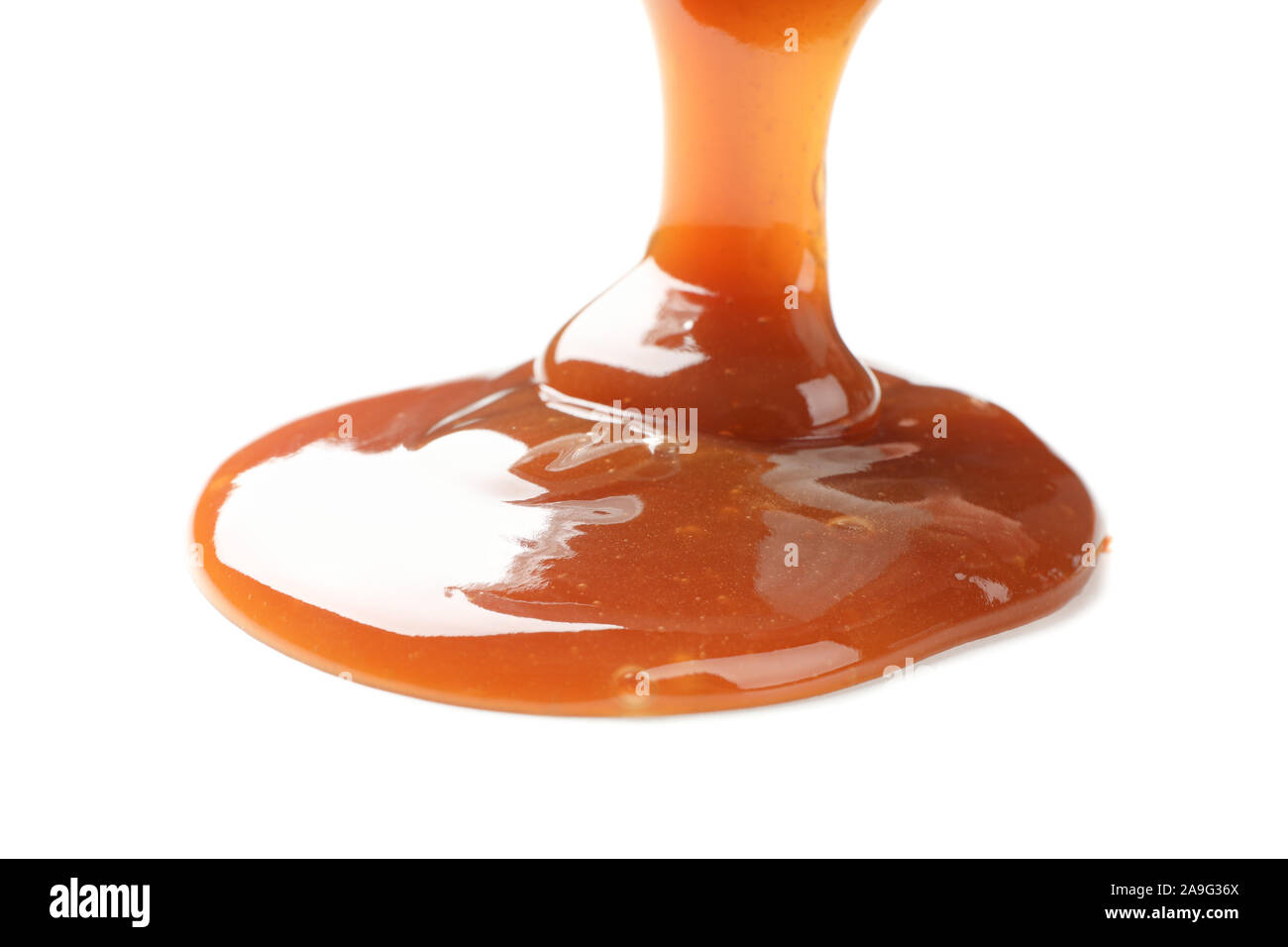 Pouring brown caramel isolated on white background Stock Photo - Alamy