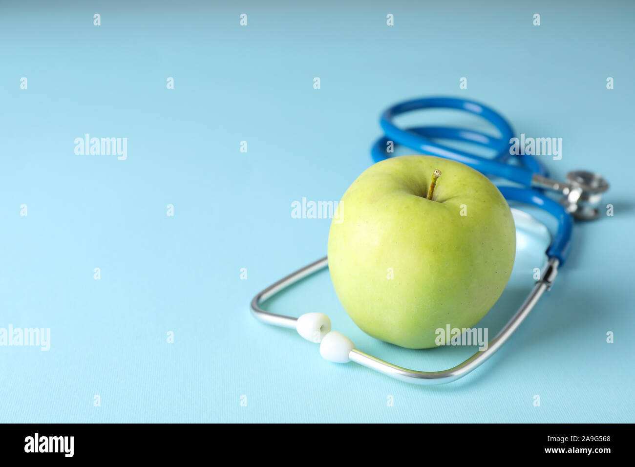 Stethoscope and apple on blue background, close up. Healthcare Stock ...
