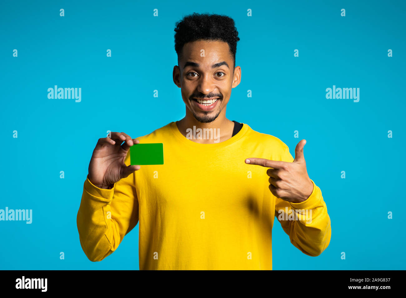 Young handsome african american man holding in hand green card. Credit ...