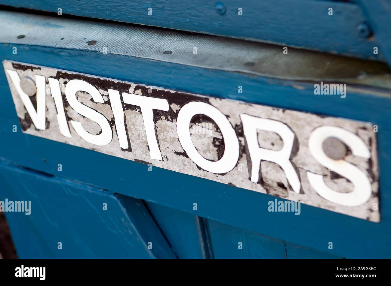 An old sign with the word visitors Stock Photo - Alamy