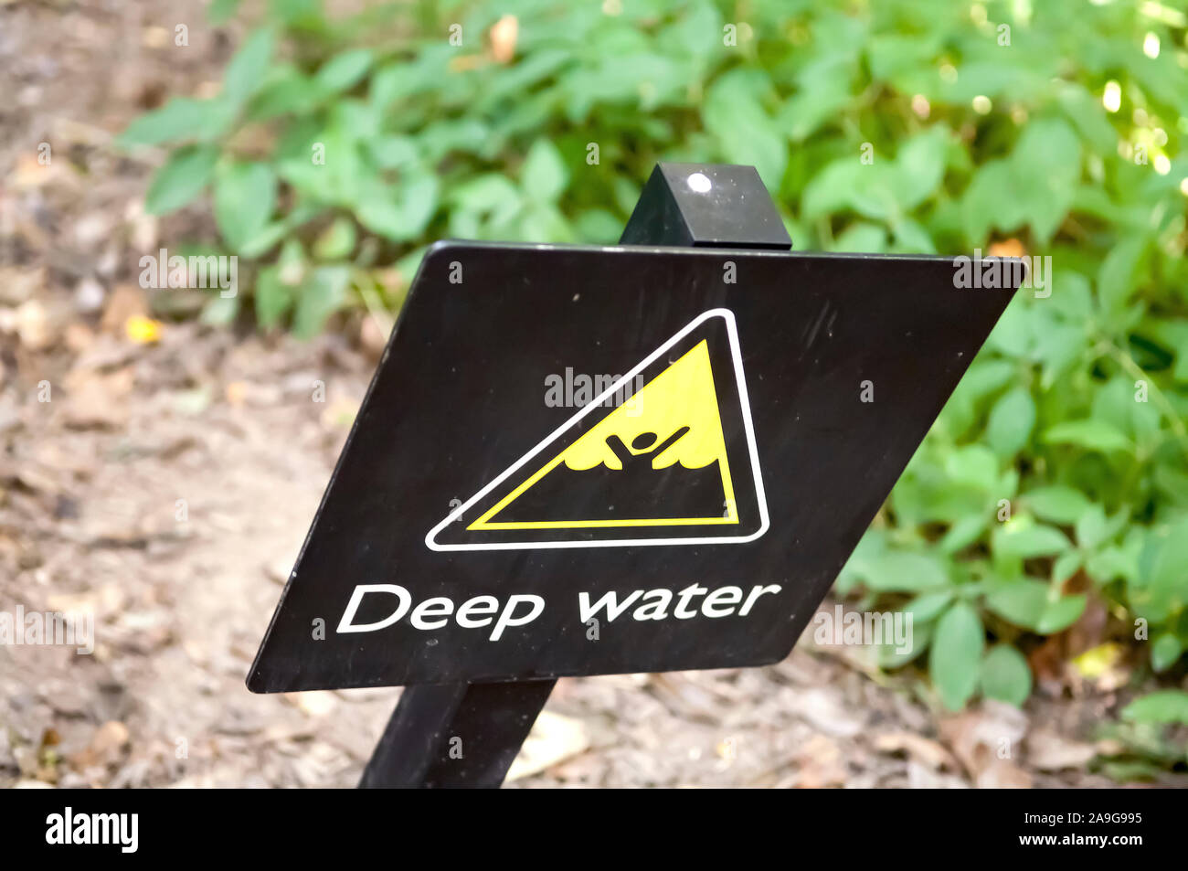 A sign warning people passing of deep water Stock Photo - Alamy