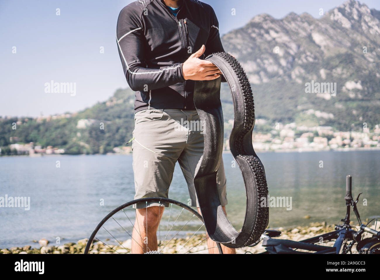 A bicycle repair man fixing a flat tire on a bike on a late afternoon ...