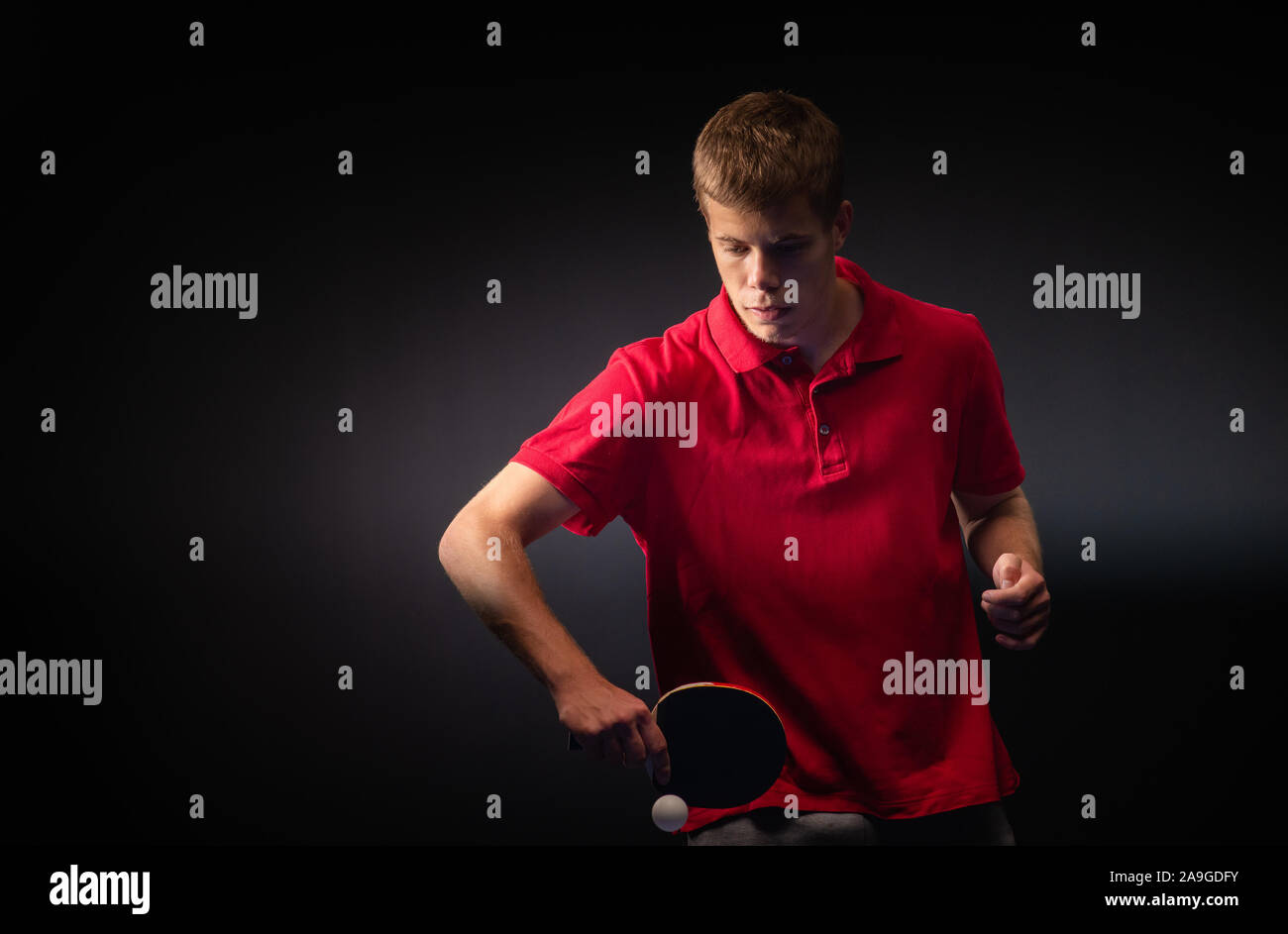 Young man playing table tennis on black studio background Stock Photo ...