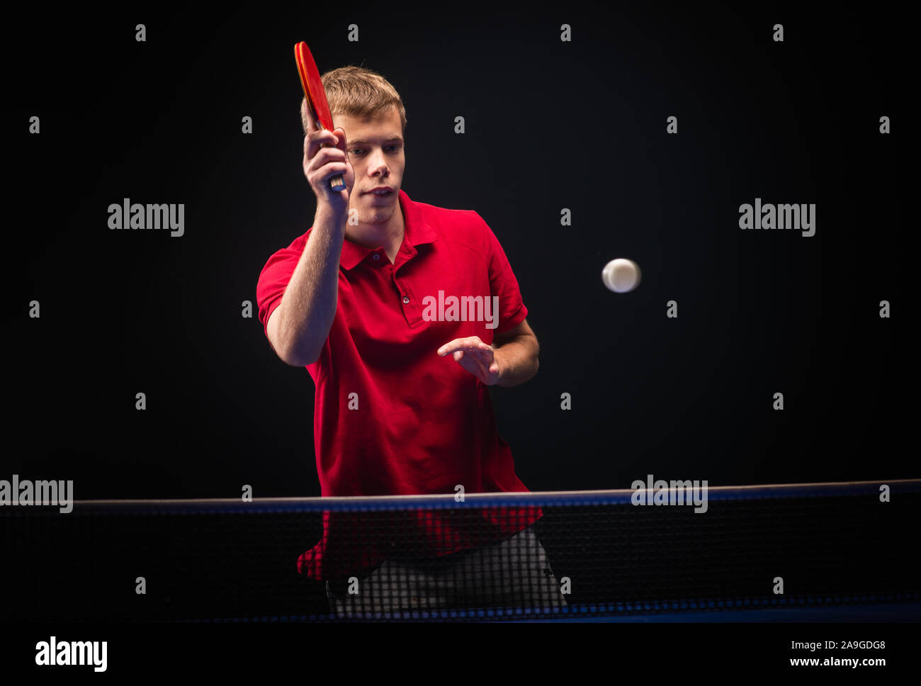 Young man playing table tennis on black studio background Stock Photo ...