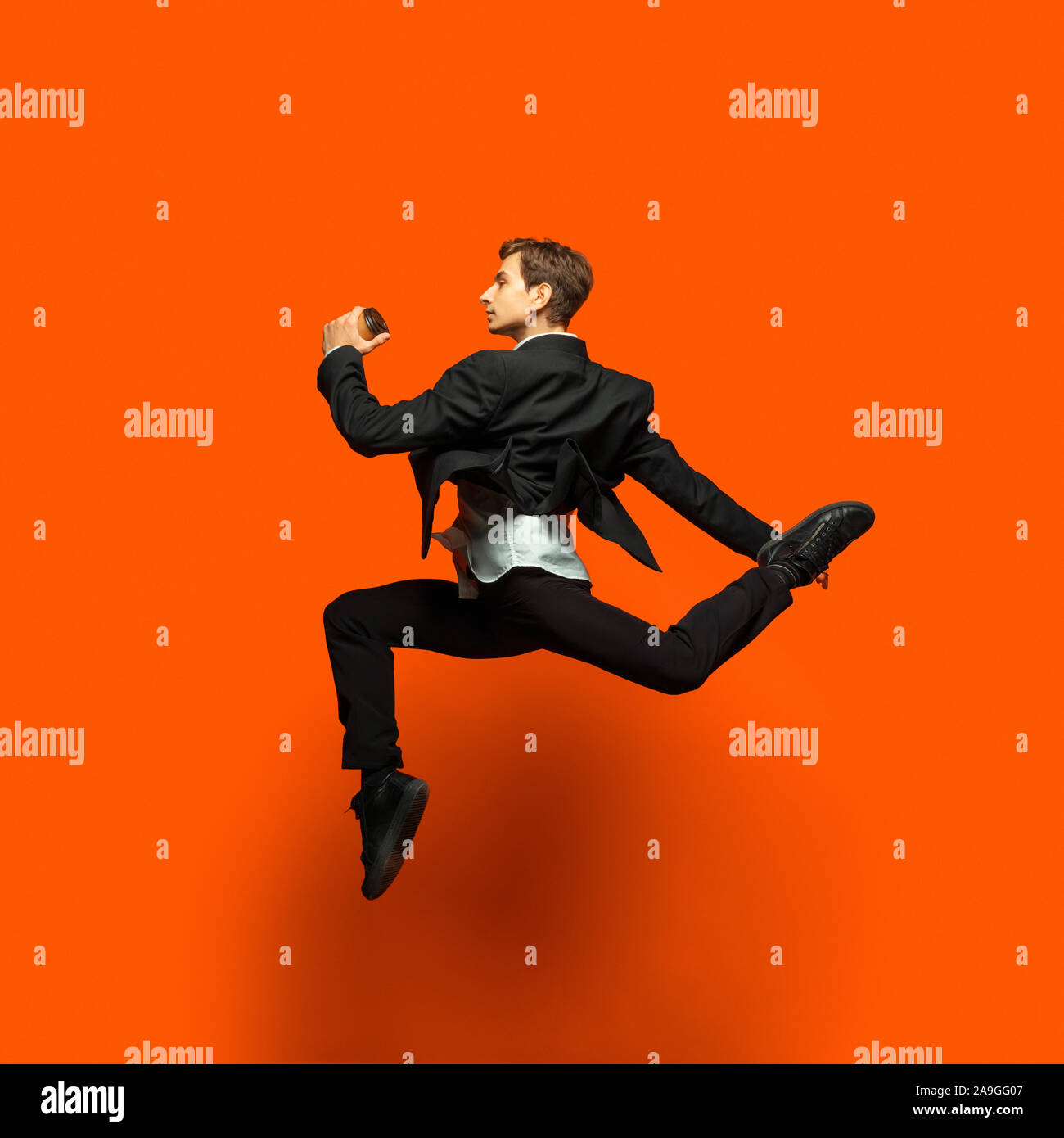 Man in casual office style clothes jumping and dancing isolated on ...