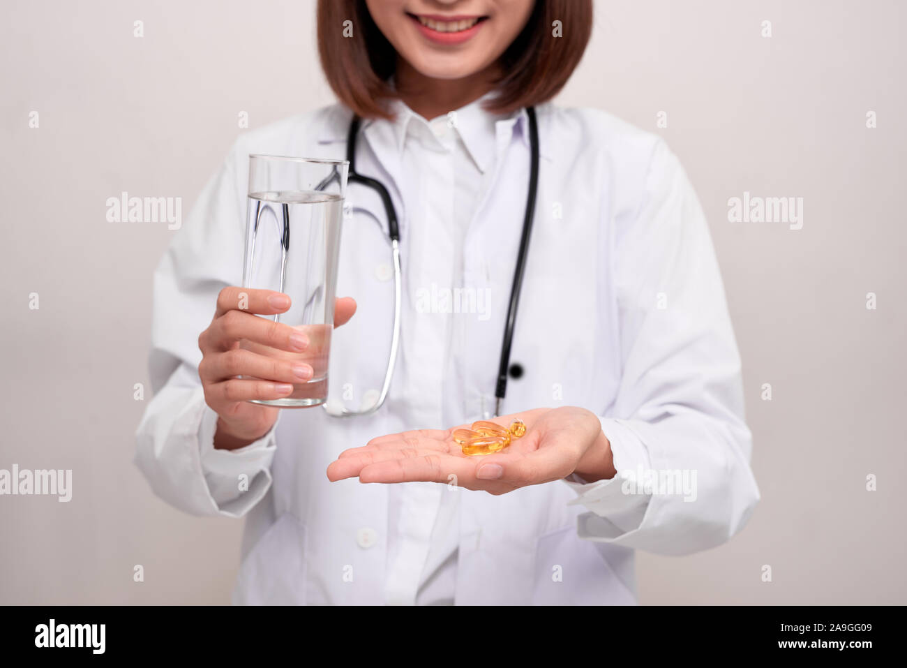 Doctor woman holding water and medicine on white background Stock Photo ...