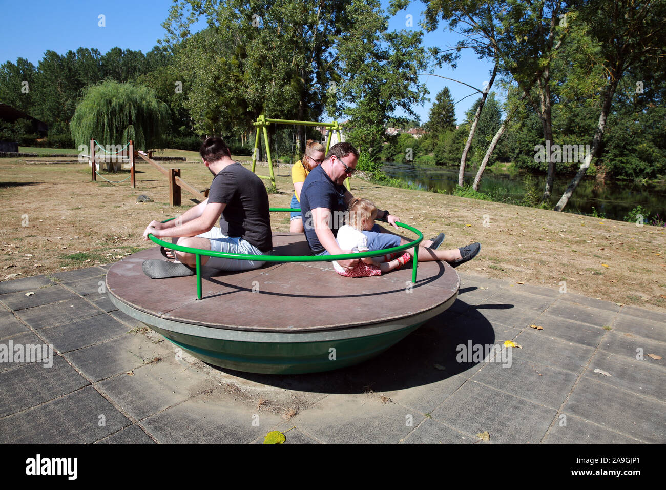 Adults and children on a roundabout the park Stock Photo - Alamy