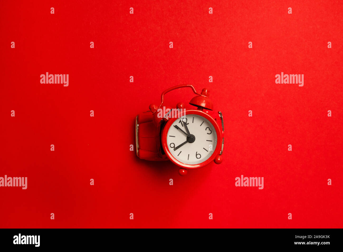 Creative concept of red alarm clock round clock on a toy model car on a ...