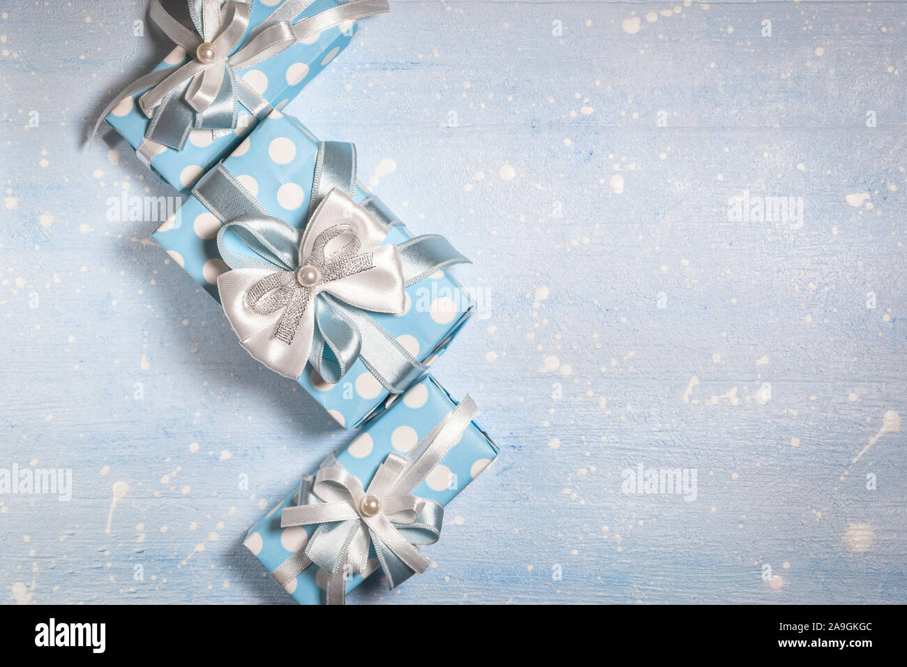 Top view of blue gift boxes with white and blue ribbon on light blue ...