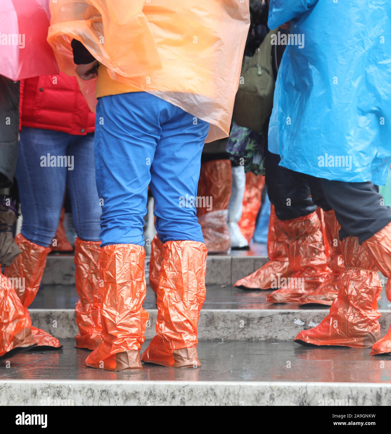people with rain coats and special plastic leggings duiring flood and ...