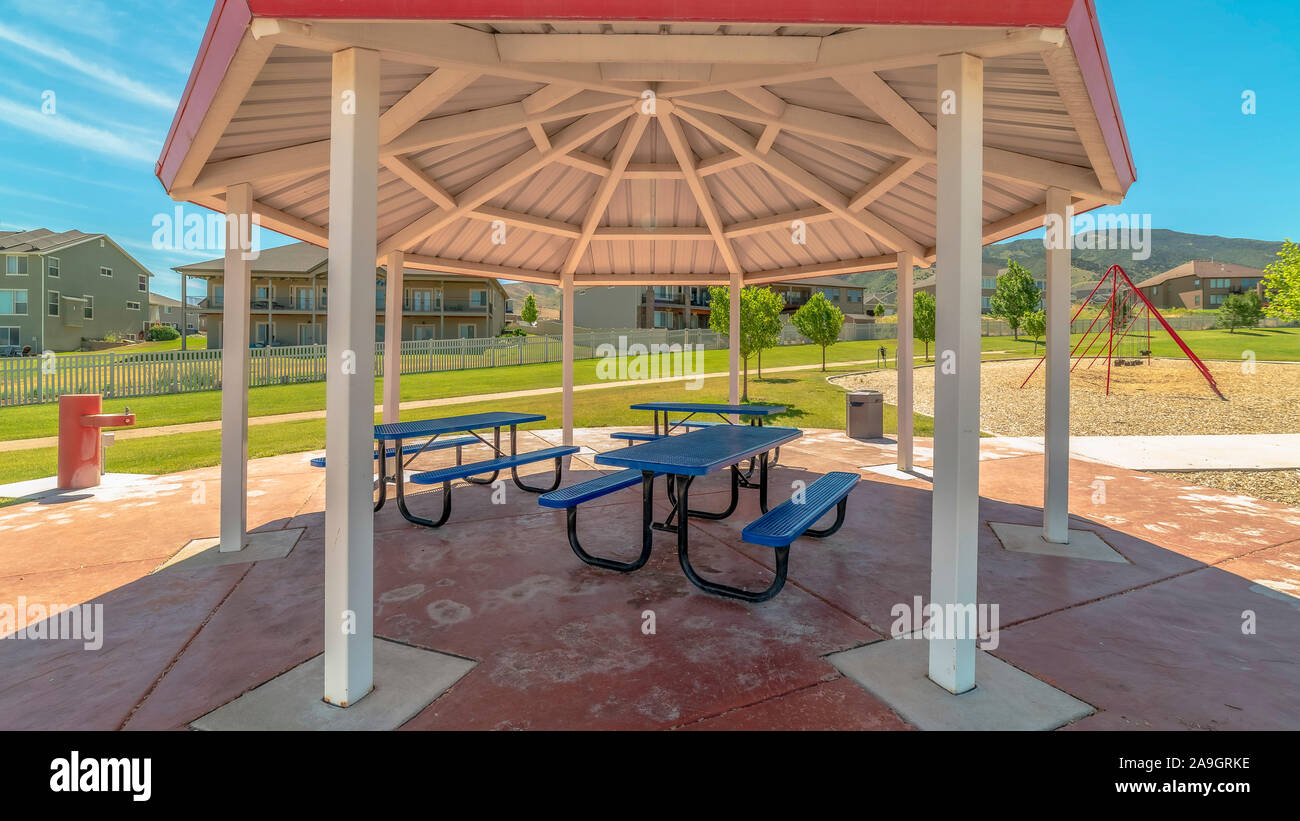 Panorama frame Octagon shape pavilion with blue tables and benches at a ...