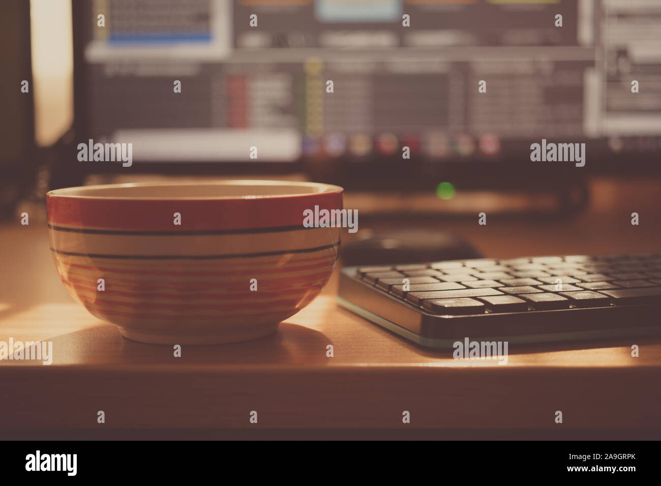 Office workspace with tea cup, keyboard and monitor. Work environment ...