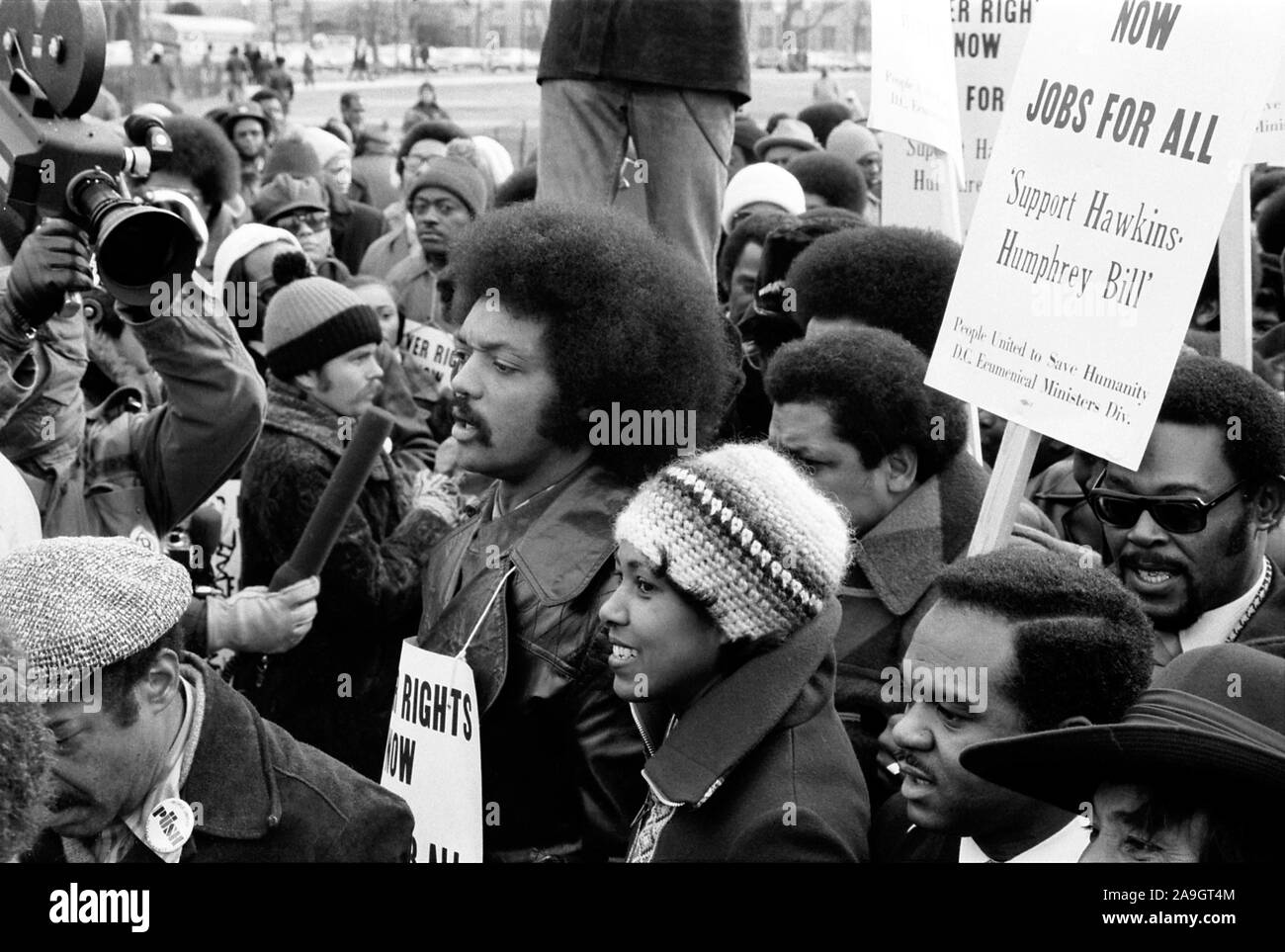 Jesse Jackson speaking into a microphone, surrounded by marchers ...