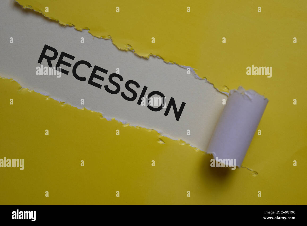 Recession Text written in torn paper Stock Photo - Alamy