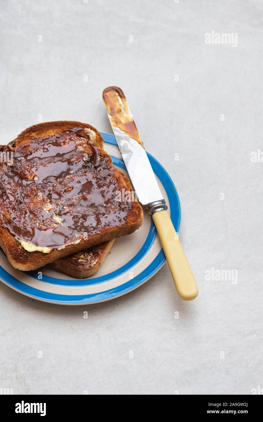 Marmite on toast on a plate on white background Stock Photo - Alamy